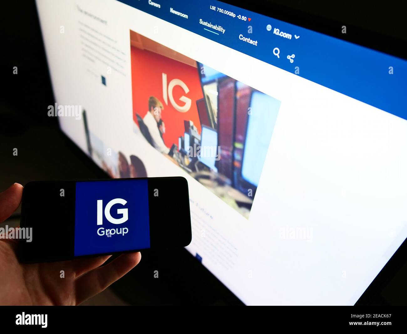 Person holding cellphone with logo of British financial services company IG Group Holdings Plc ...