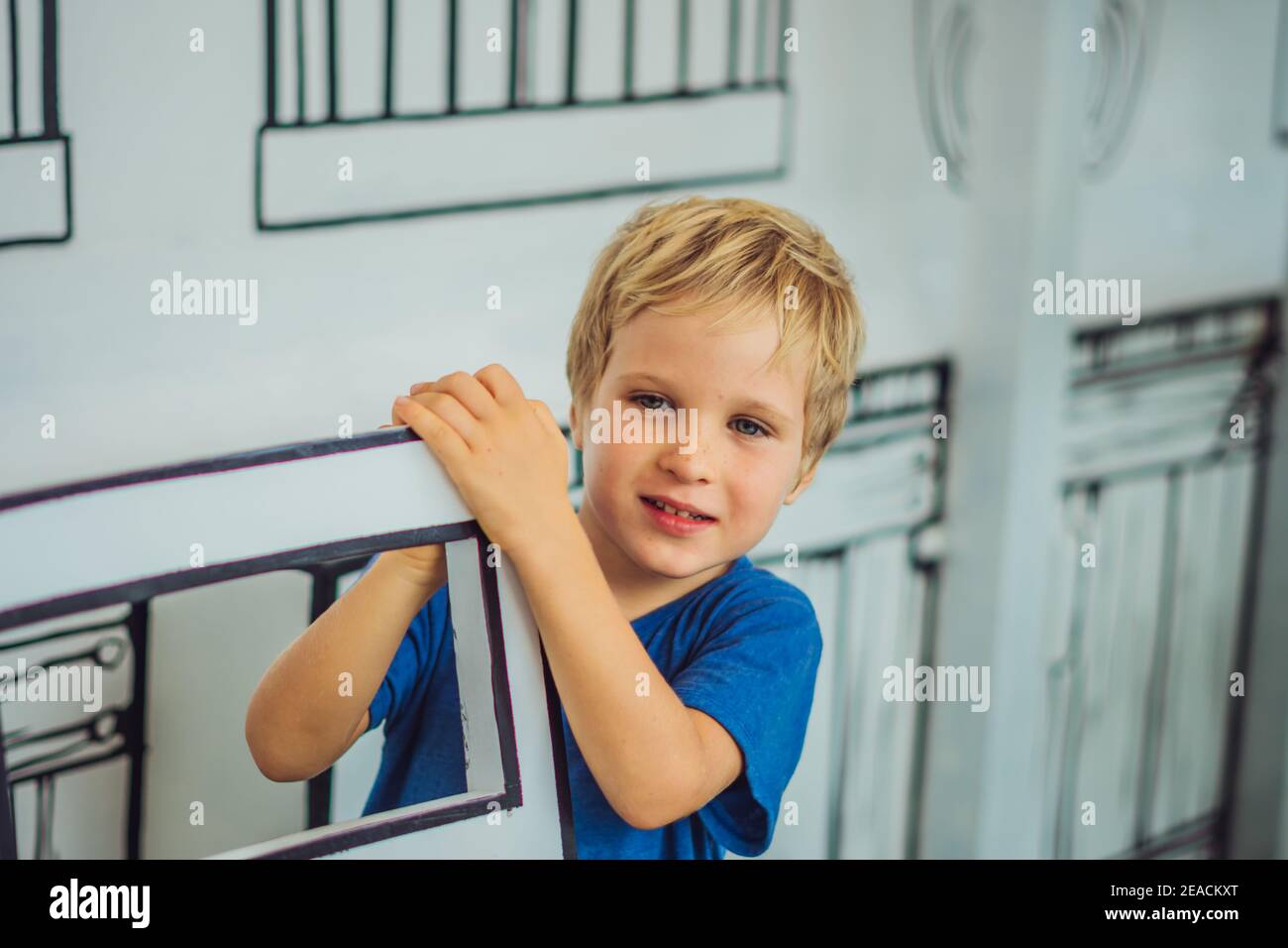 Portrait smile blue eyed freckled blond boy, hide behind chair, micro ...