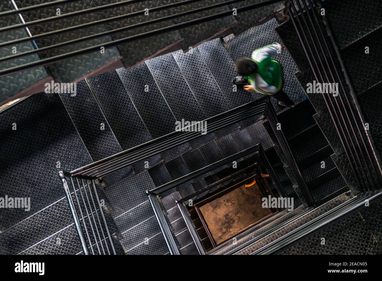 A man walking up the square steel stairwell,view from the top Stock ...