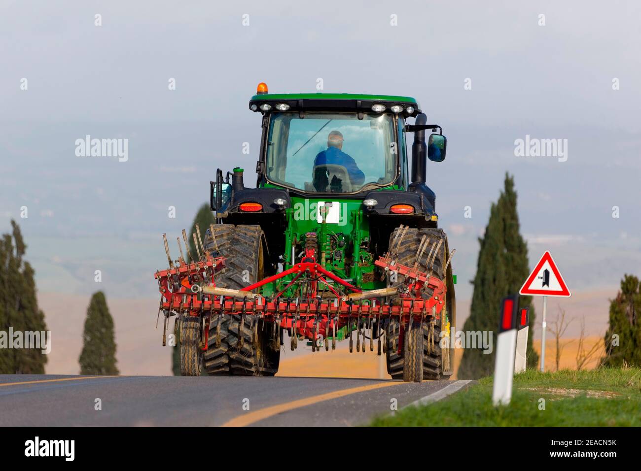 Farmer drives his tractor on the road Stock Photo - Alamy