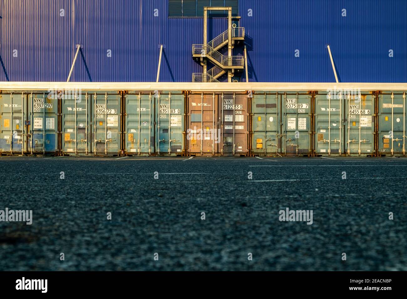 View of many shipping containers doors with fire escape background ...