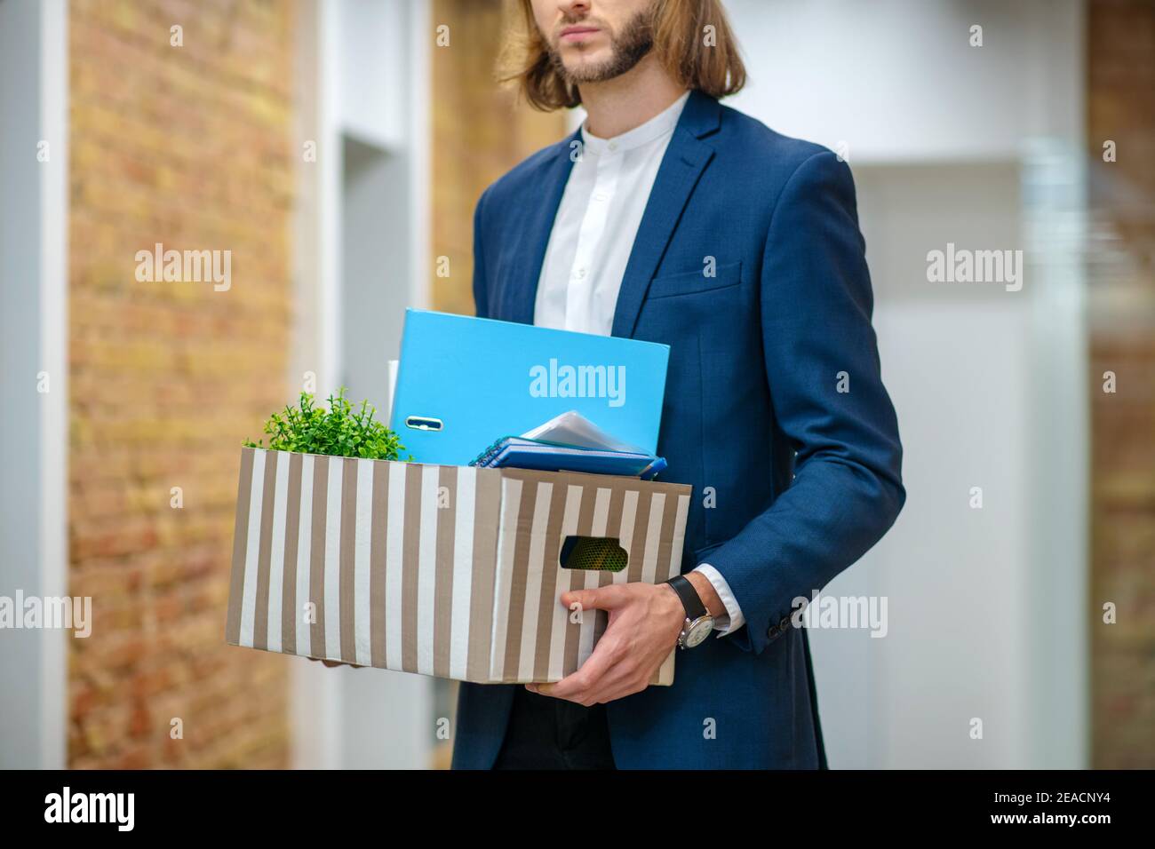 Standing man in business suit with box in hands Stock Photo - Alamy