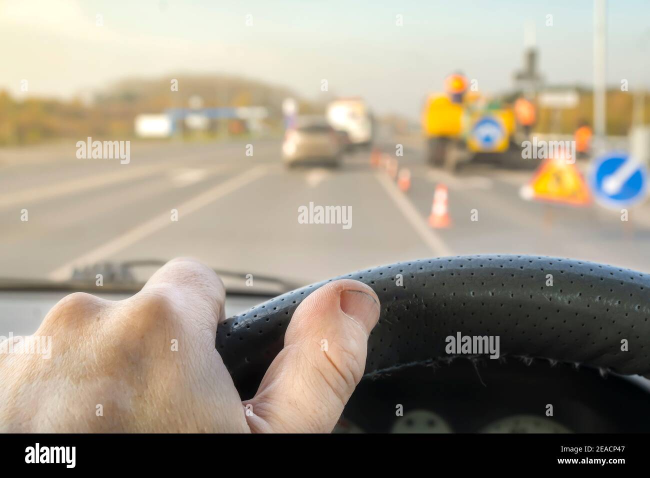 driver's hand on the steering wheel of a car that passes through the ...