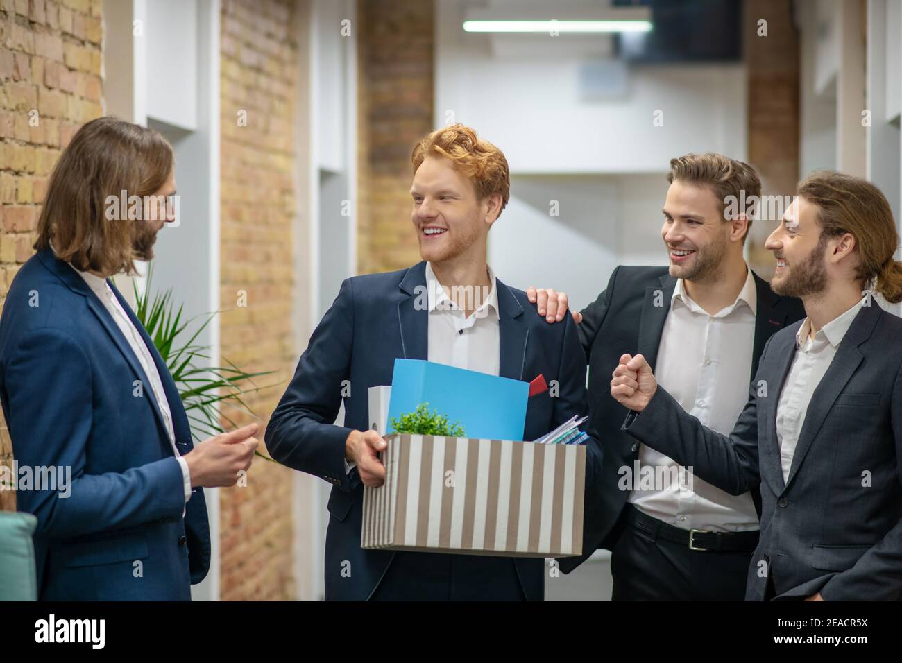 Group of men talking in office corridor Stock Photo - Alamy