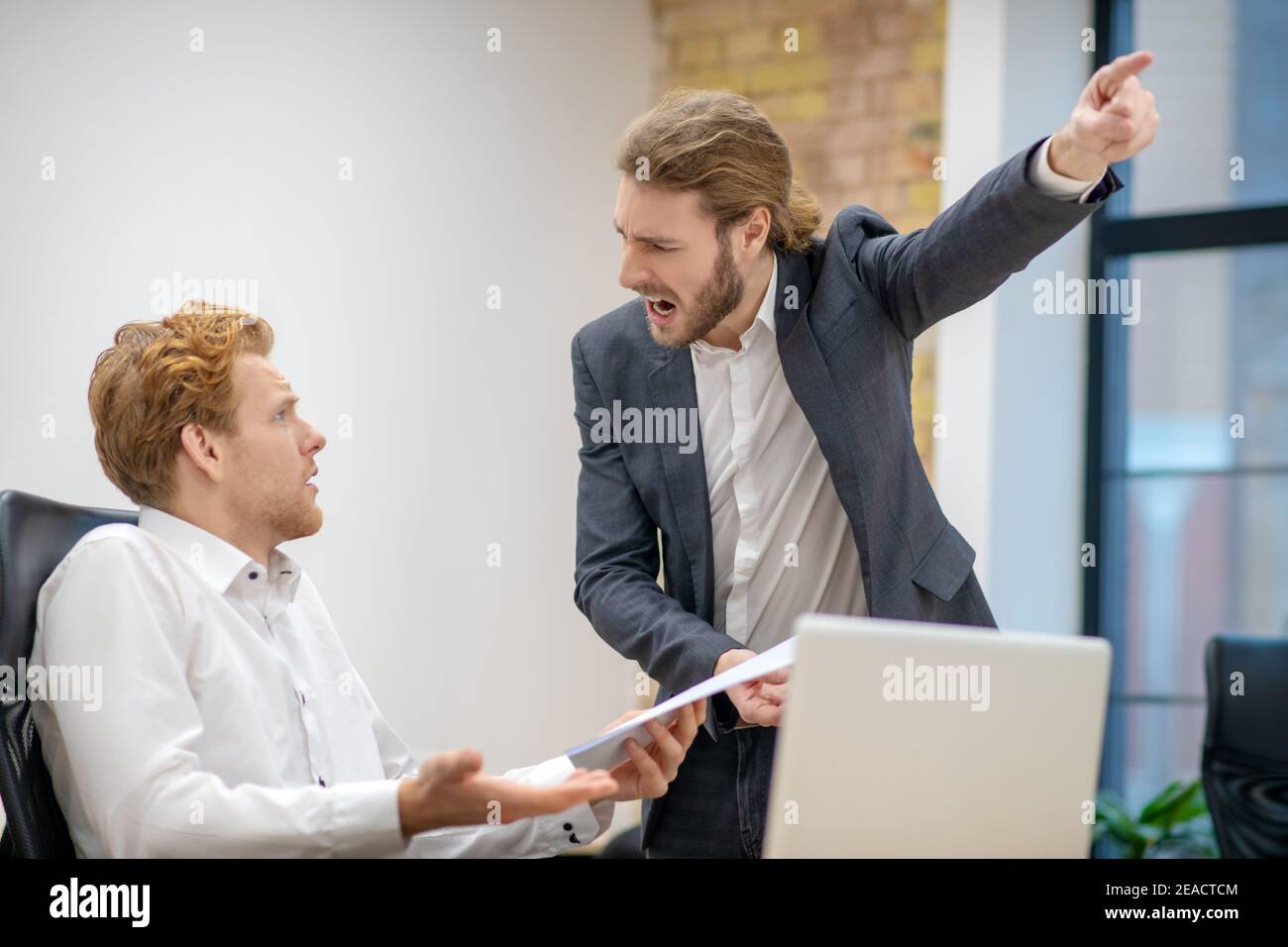 Screaming man pointing with hand and bewildered colleague Stock Photo ...