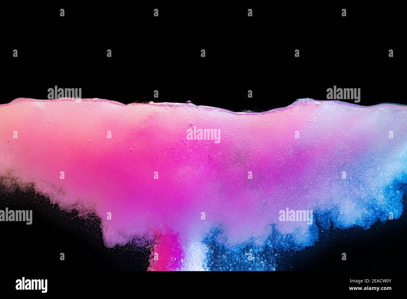Pink bubbly boiling water against black background Stock Photo - Alamy