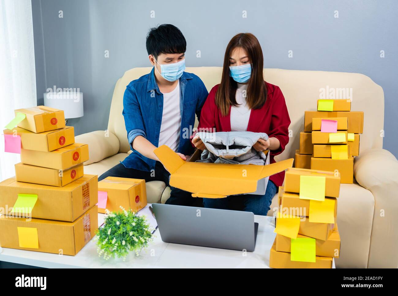 couple online entrepreneur packing a parcel box for delivery at home ...