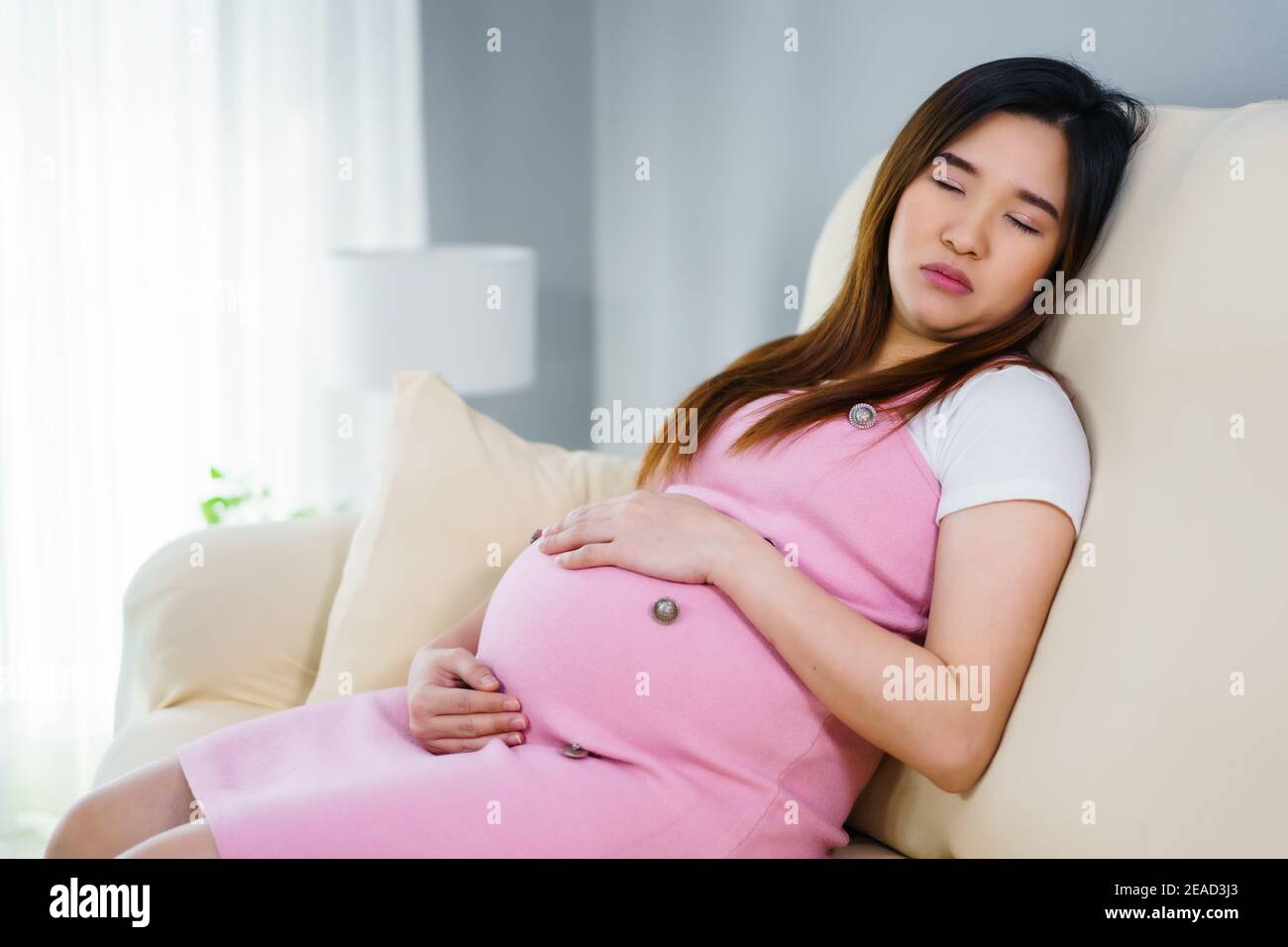 pregnant woman sleeping on sofa in the living room Stock Photo - Alamy