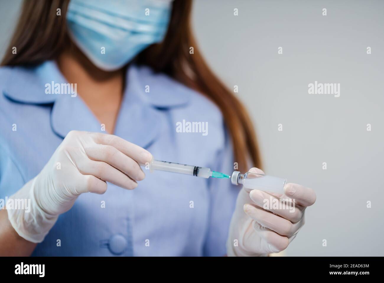 female doctor drawing vaccine bottle into syringe injection medicine ...