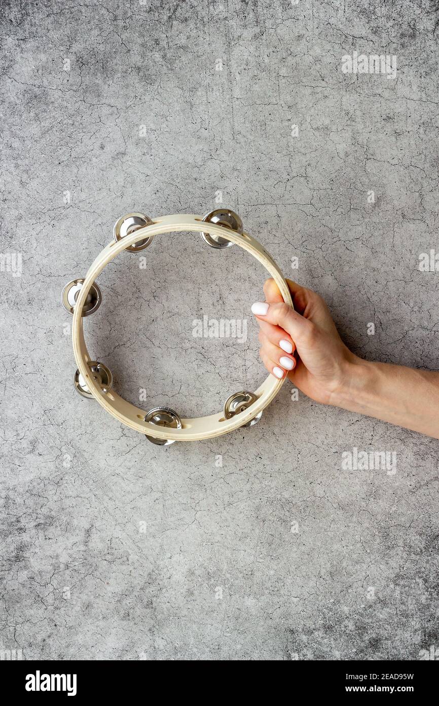 Wooden tambourine in hand. Percussion musical instrument, top view ...