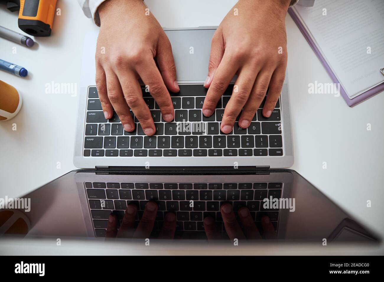 Male hands typing message on laptop on the table in room indoors Stock ...