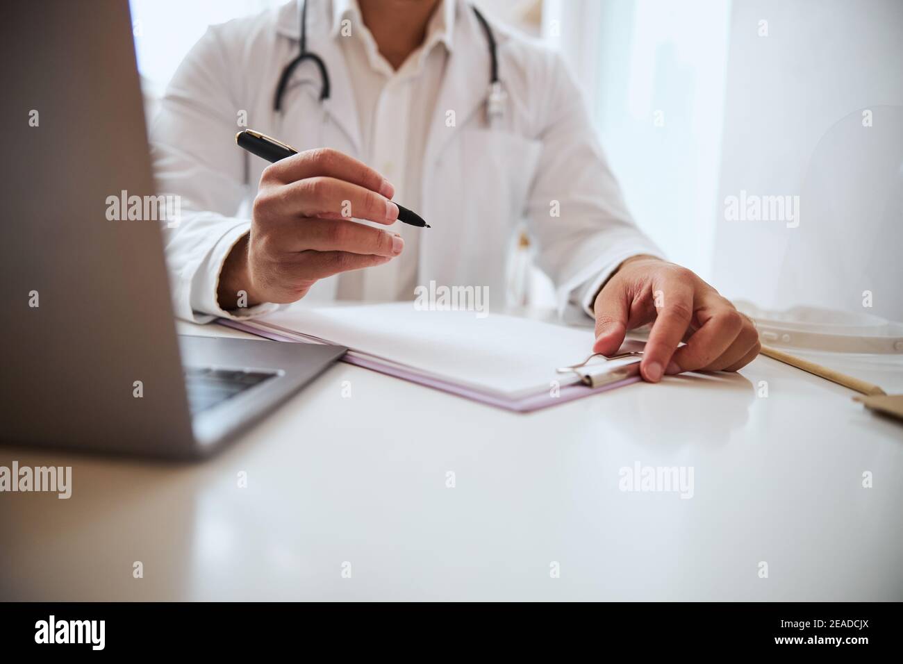 Therapist doing notes on the documents at the work desk with ...