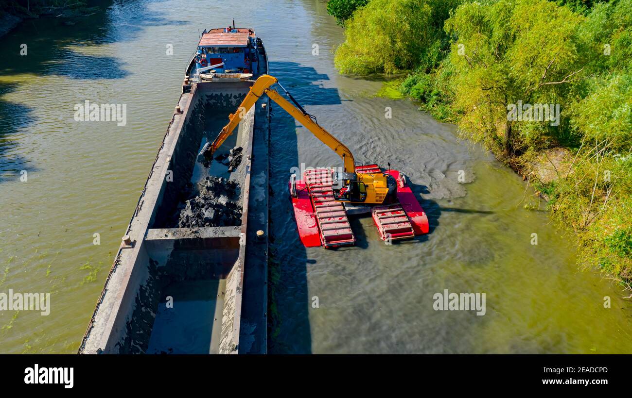 Above view on excavator dredge is dredging, working on river, canal ...