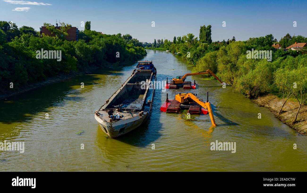 Above view on two excavators dredge as they dredging, working on river ...