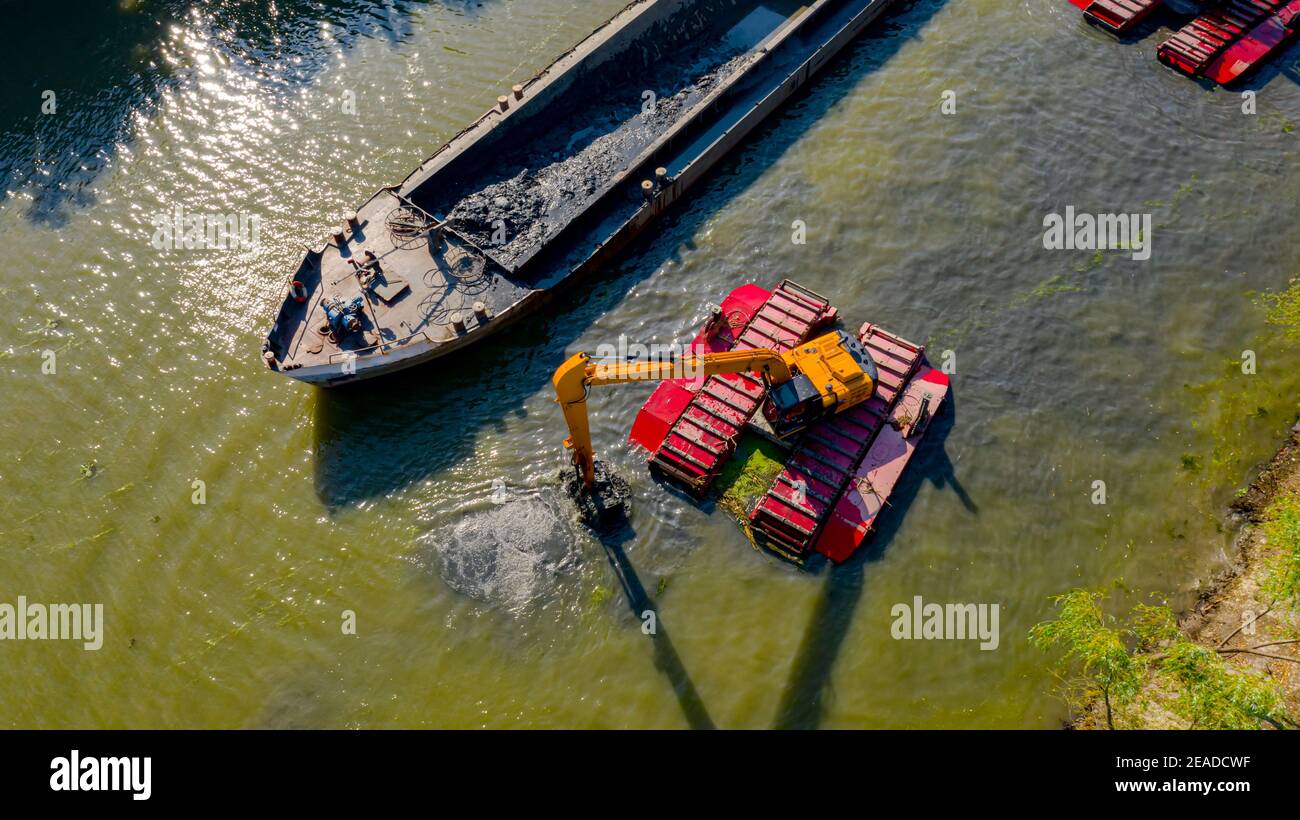Above top view on excavator dredge is dredging, working on river, canal ...