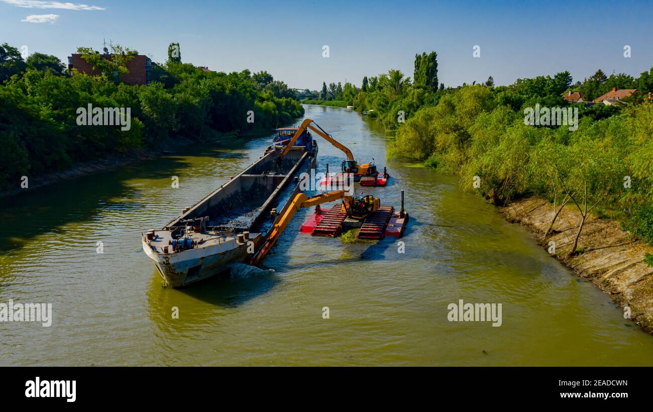 Above view on two excavators dredge as they dredging, working on river ...