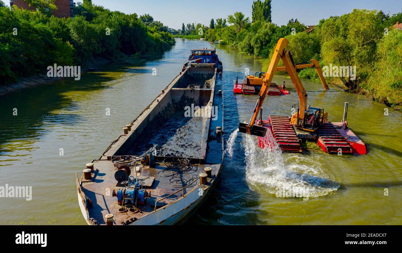 Above view on two excavators dredge as they dredging, working on river ...