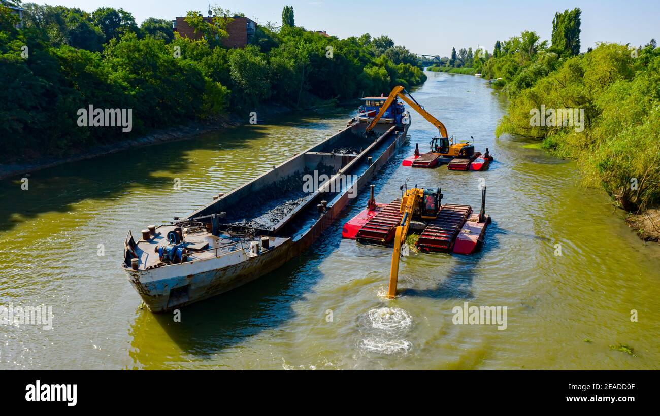 Above view on two excavators dredge as they dredging, working on river ...