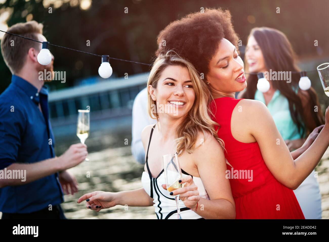 Group of friends drinking, chatting and having a fun at outdoor party ...