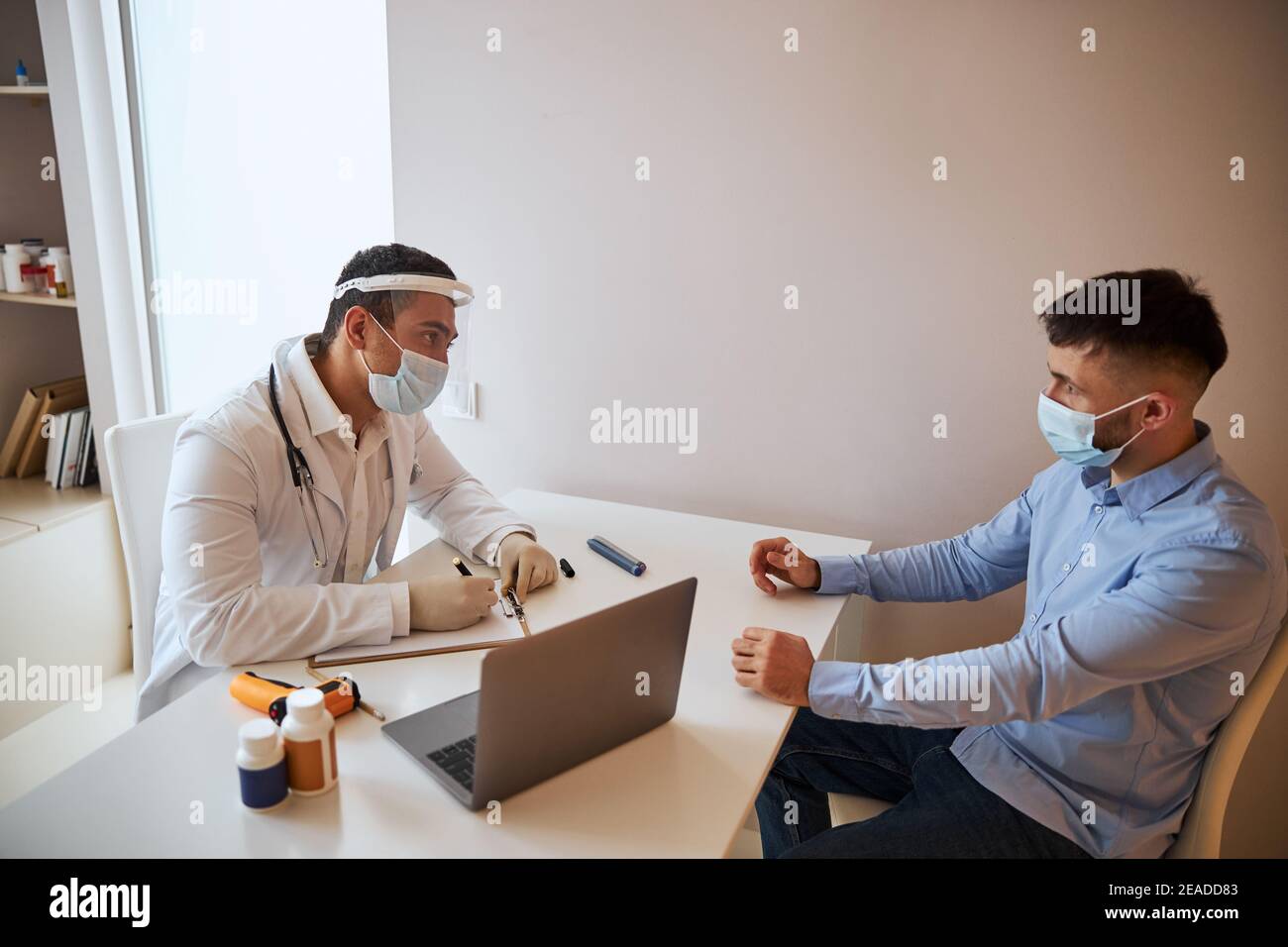 Doctor having dialogue with man patient in medical office Stock Photo ...