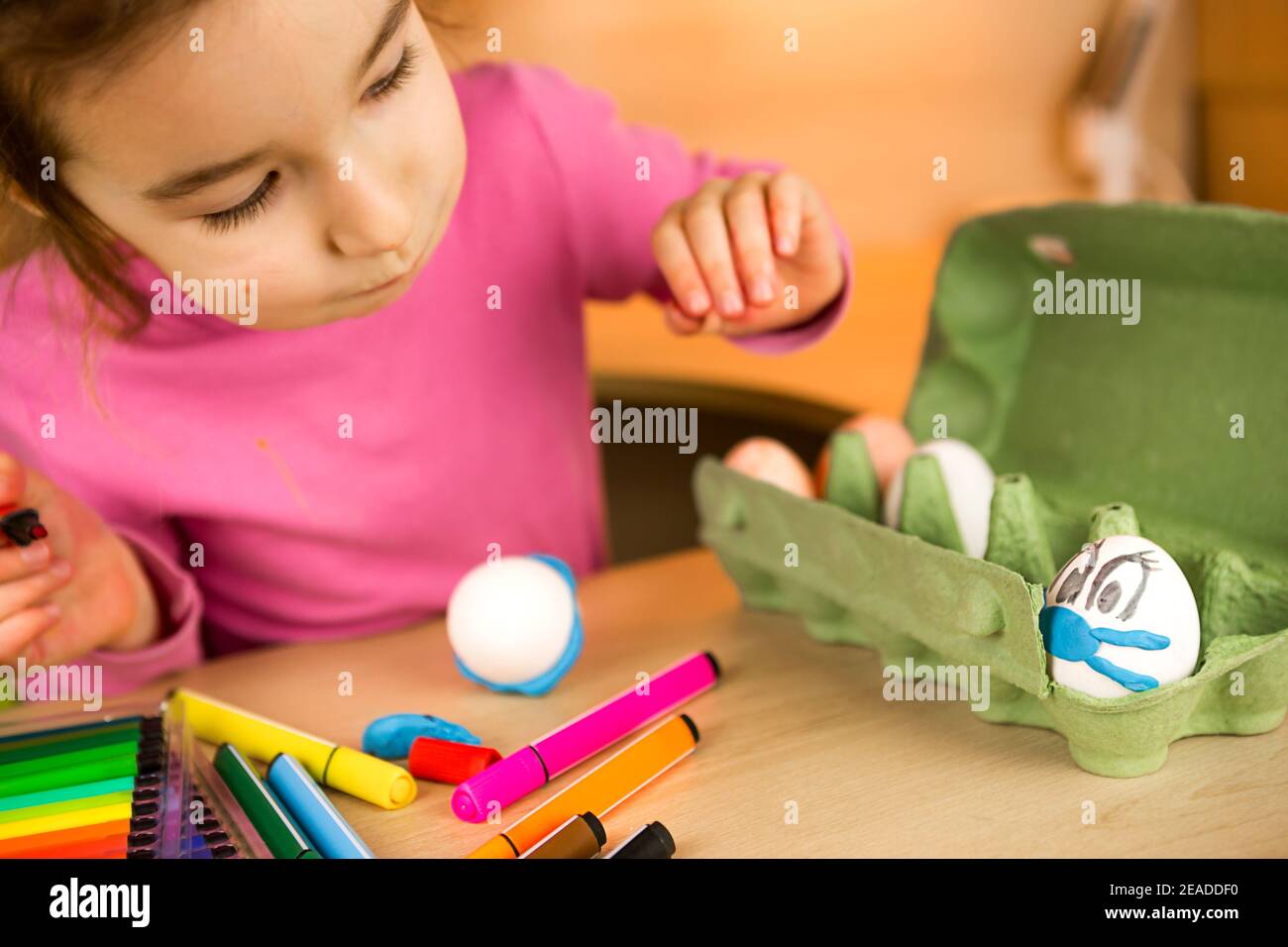 Girl with bunny ears makes medical masks out of plasticine for Easter ...