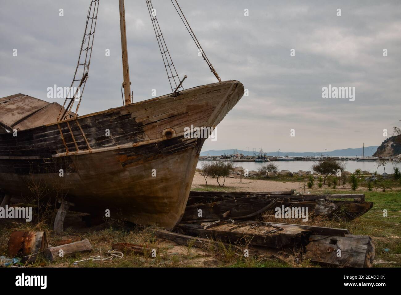 Old wooden boat left rotting on the shore near harbour Stock Photo - Alamy