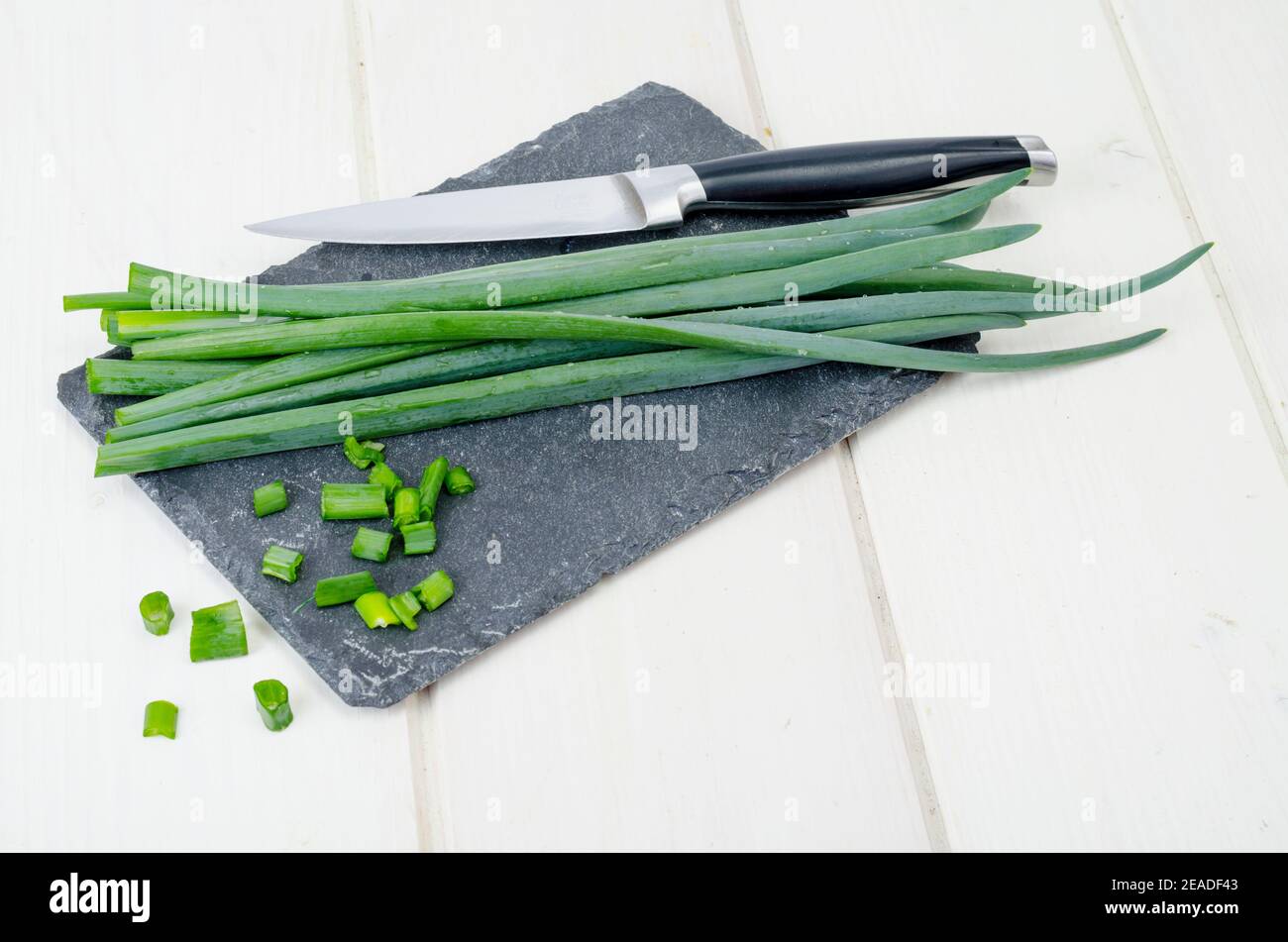 Cutting stalks of green onions, an ingredient in cooking. Studio Photo ...