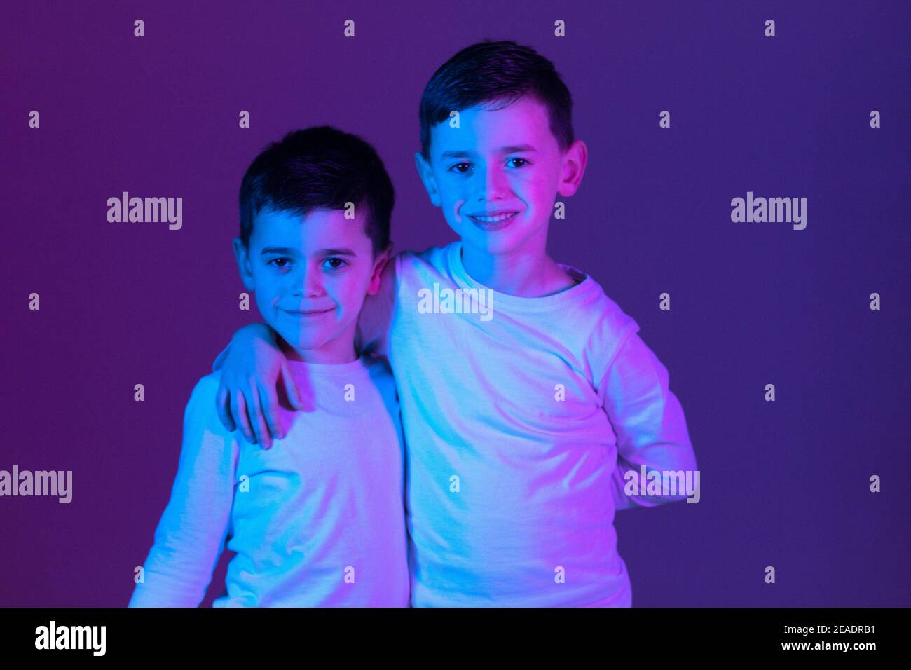 Two children illuminated with neon lights. Sibling love Stock Photo - Alamy