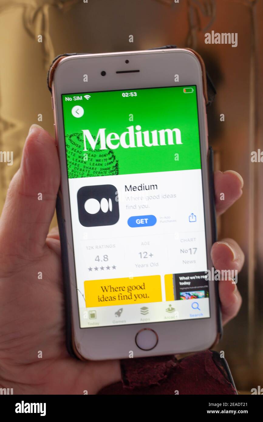Close-up of a hand holding mobile phone with Medium tech app on screen ...