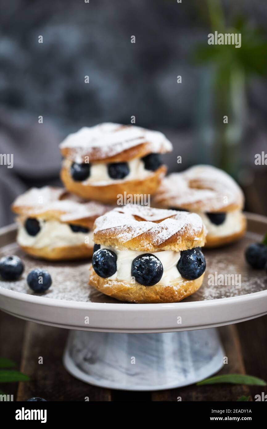 Cream puff rings (choux pastry) decorated with fresh blueberries Stock ...