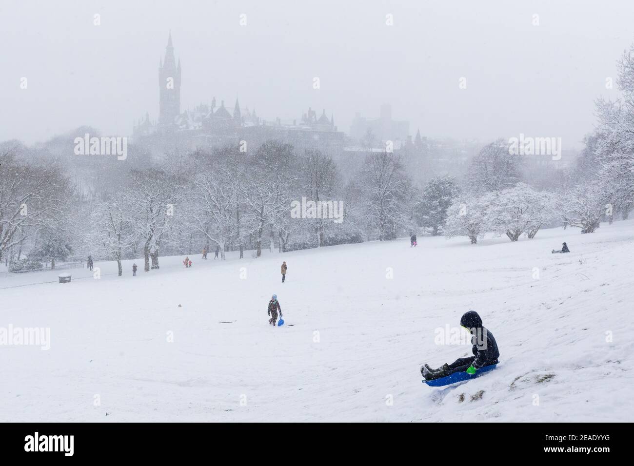 People enjoying winter snow in Kelvingrove Park Glasgow UK. Children on ...