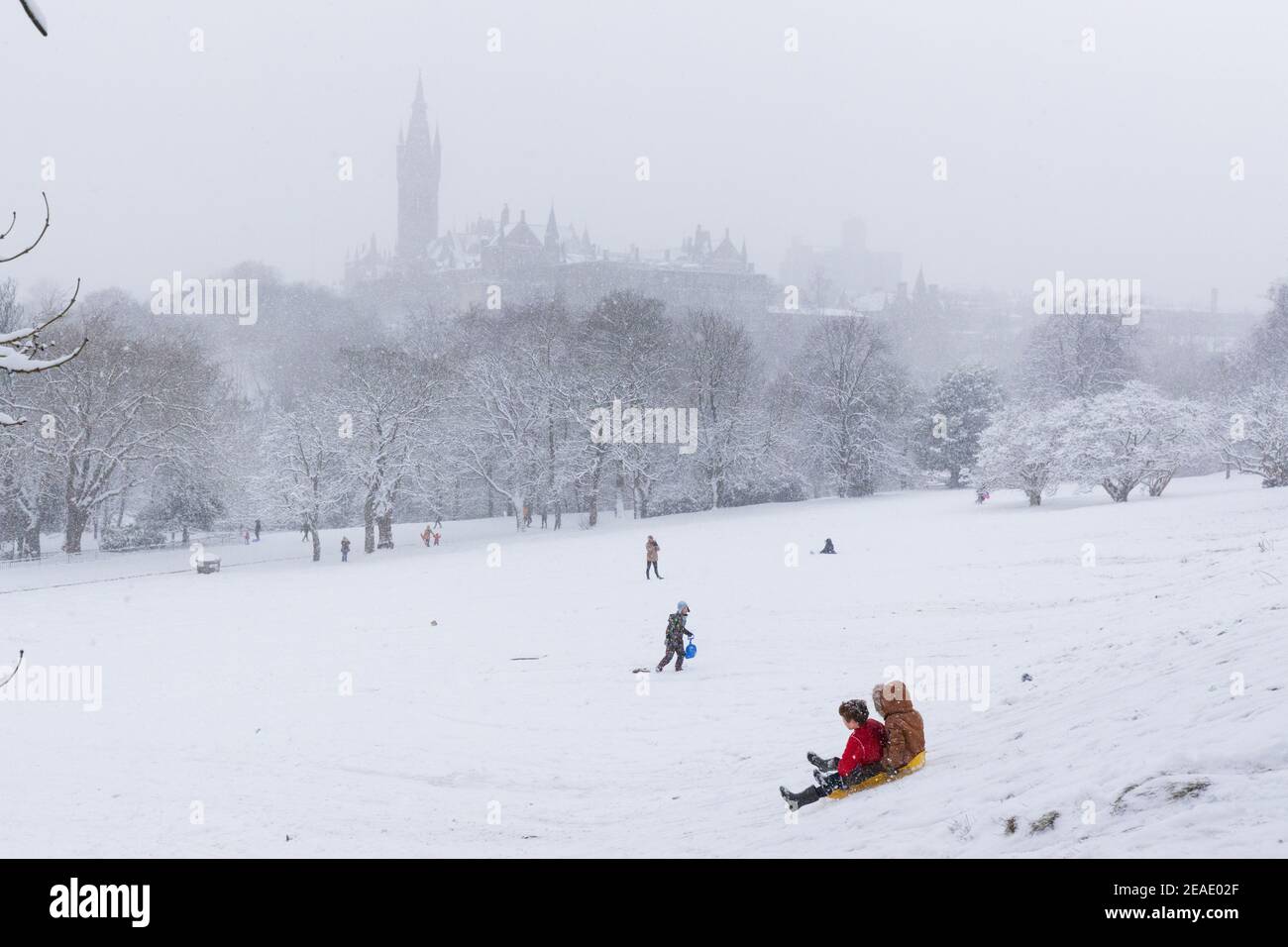 People enjoying winter snow in Kelvingrove Park Glasgow UK. Children on ...
