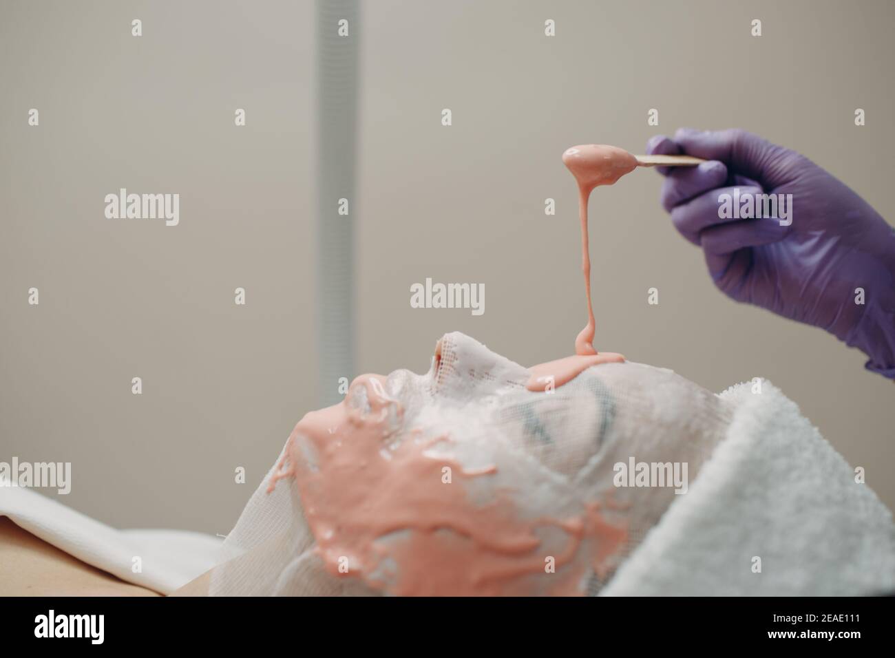 Alginate face mask application process. A female hands of a beautician ...