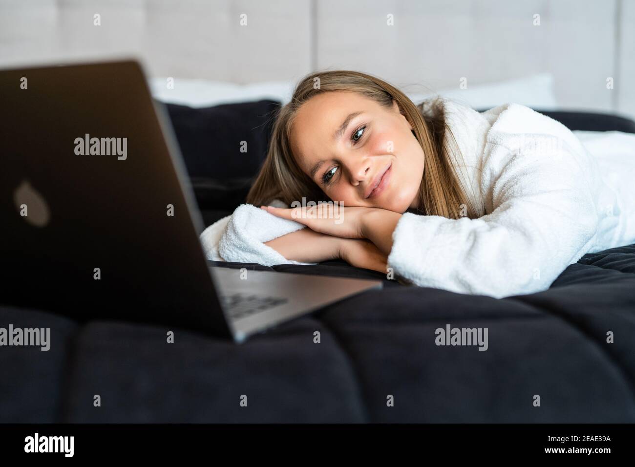 Young woman working on computer in bed Stock Photo - Alamy