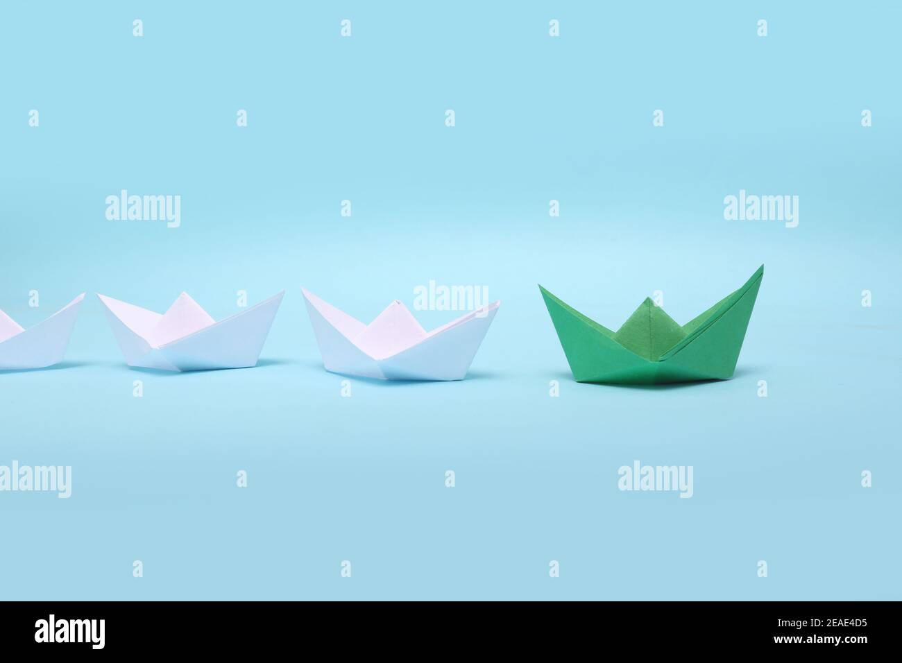 Leadership concept. Blue leader paper ship leading among white on green ...