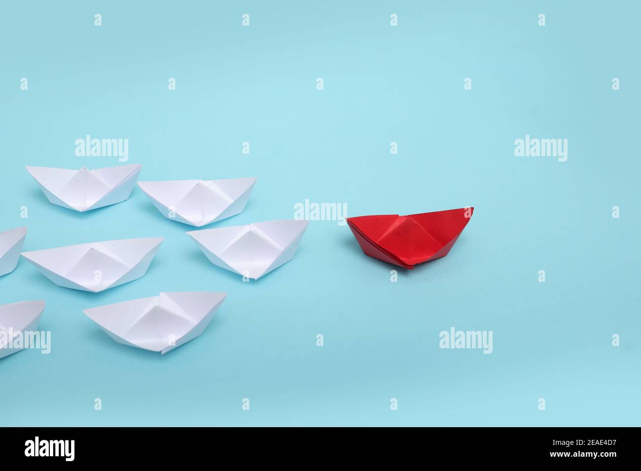 Leadership concept. Red leader paper ship leading among white on blue ...