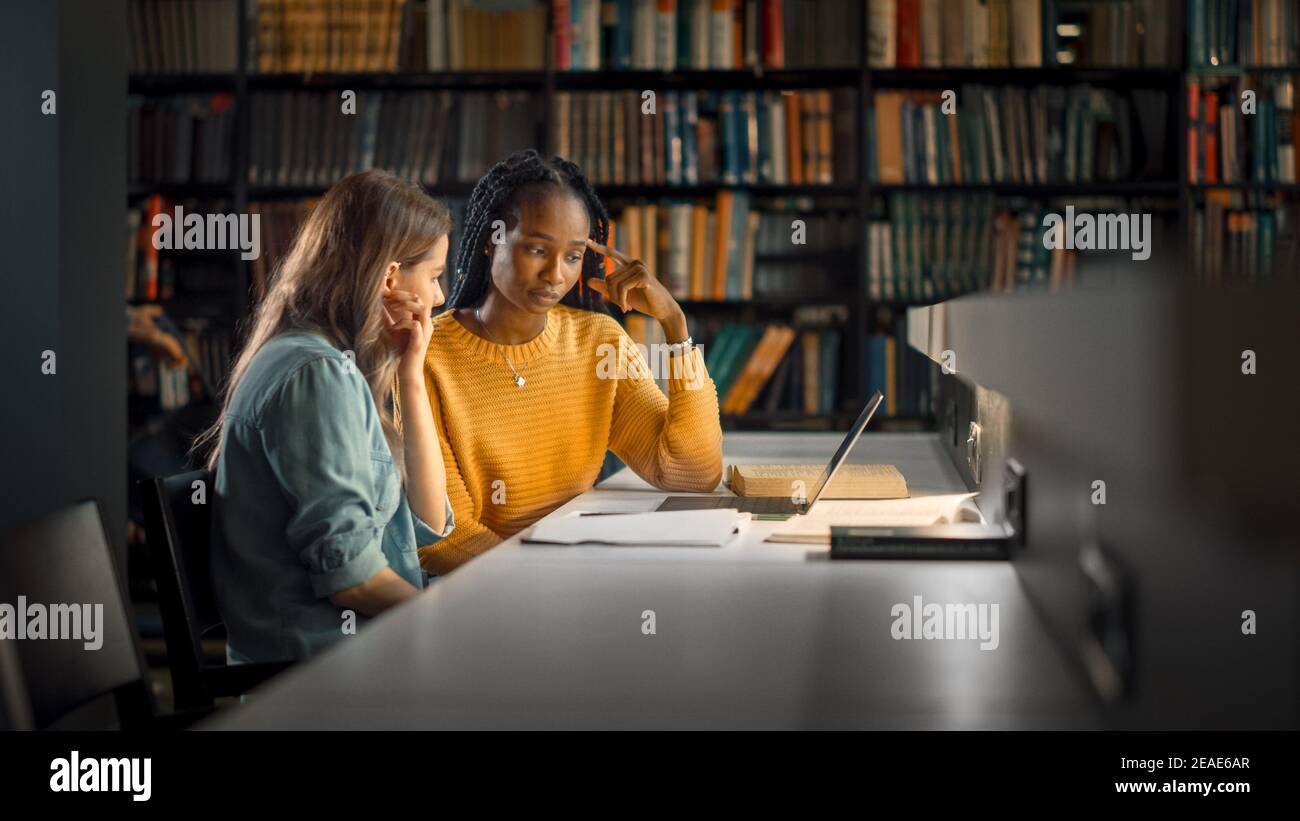 University Library: Two Gifted Girl Students Study, Use Laptop Computer ...