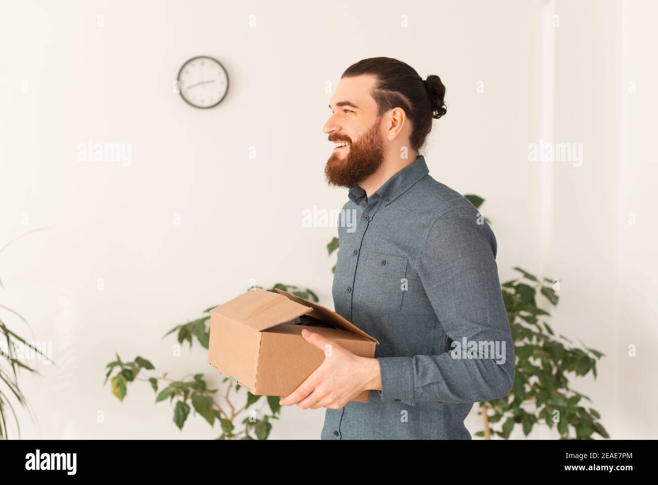 Photo of young smiling man moving to another office or job Stock Photo ...