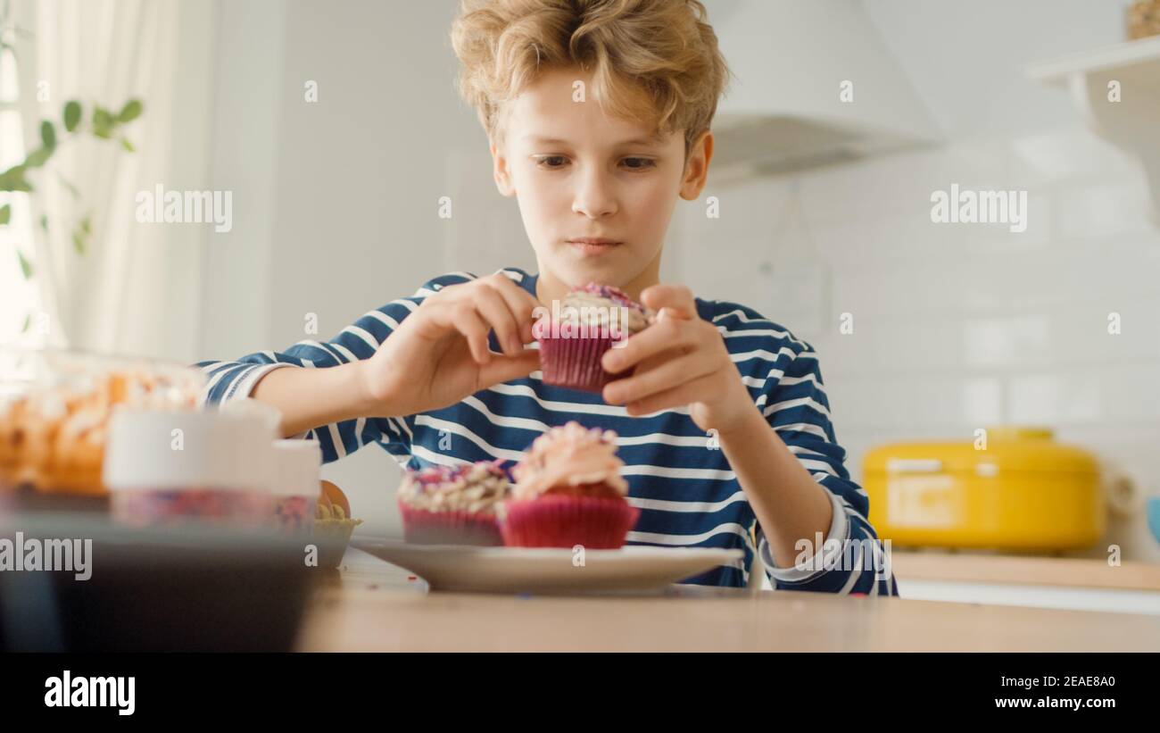 In the Kitchen: Adorable Boy Eats Creamy Cupcake with Frosting and ...