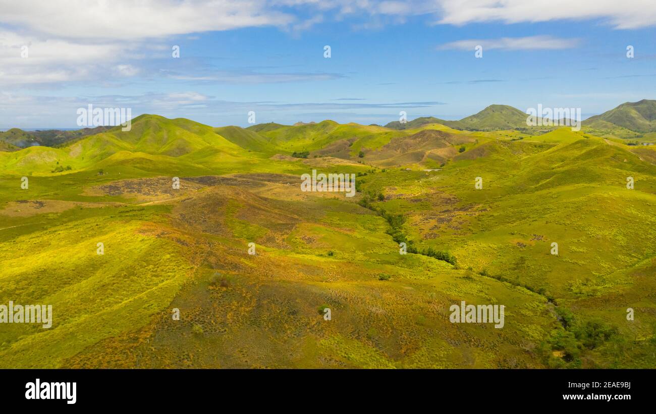 Mountain slopes and hills with tropical vegetation under a blue sky ...