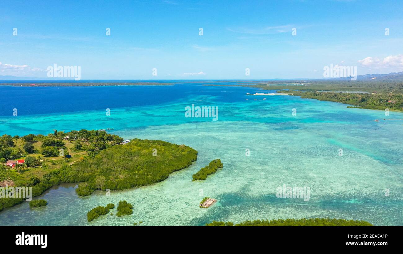 Island in the open sea against a blue sky with clouds. Cabilao Island ...
