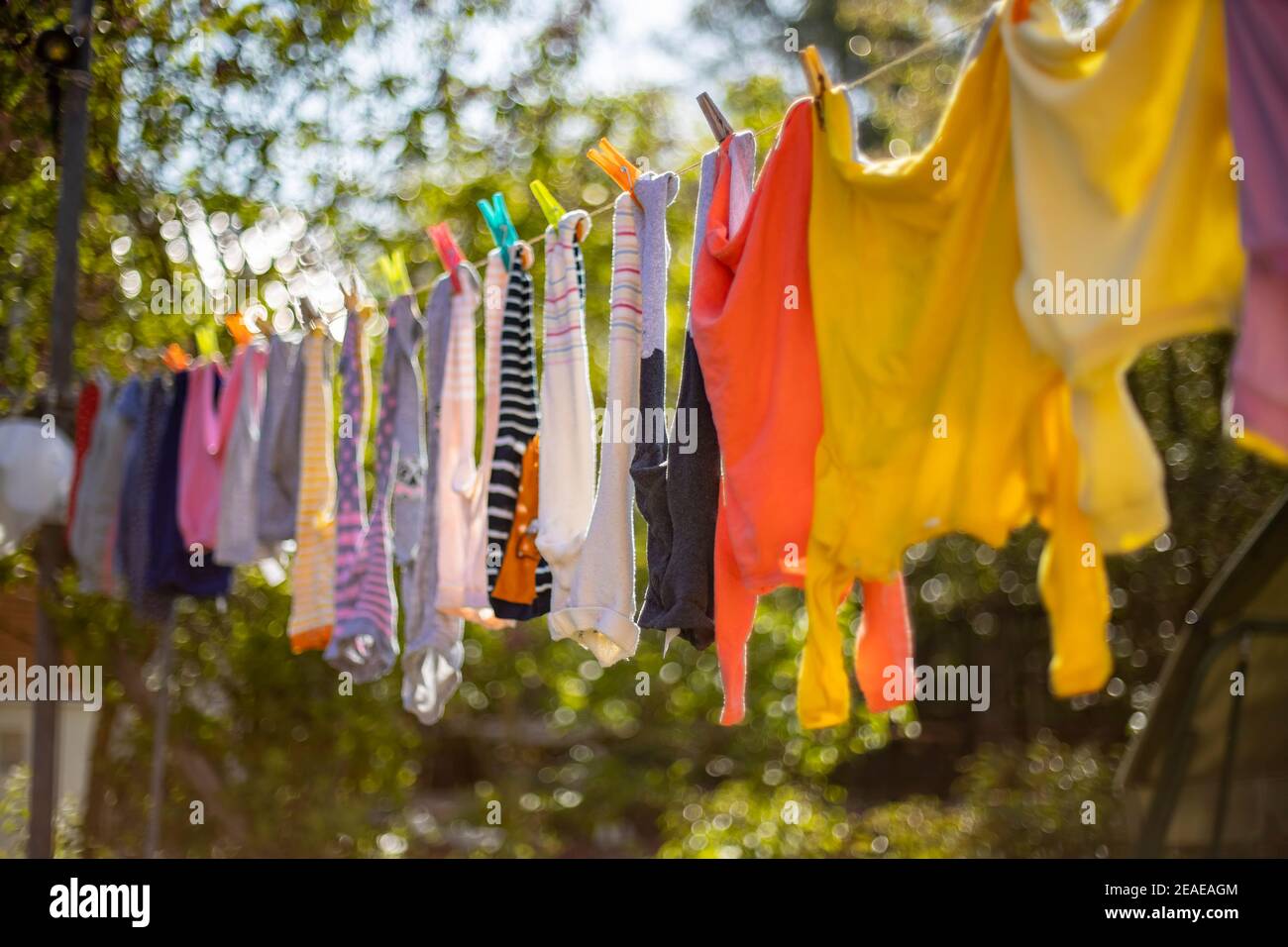 Baby cute clothes hanging on the clothesline outdoor. Child laundry ...