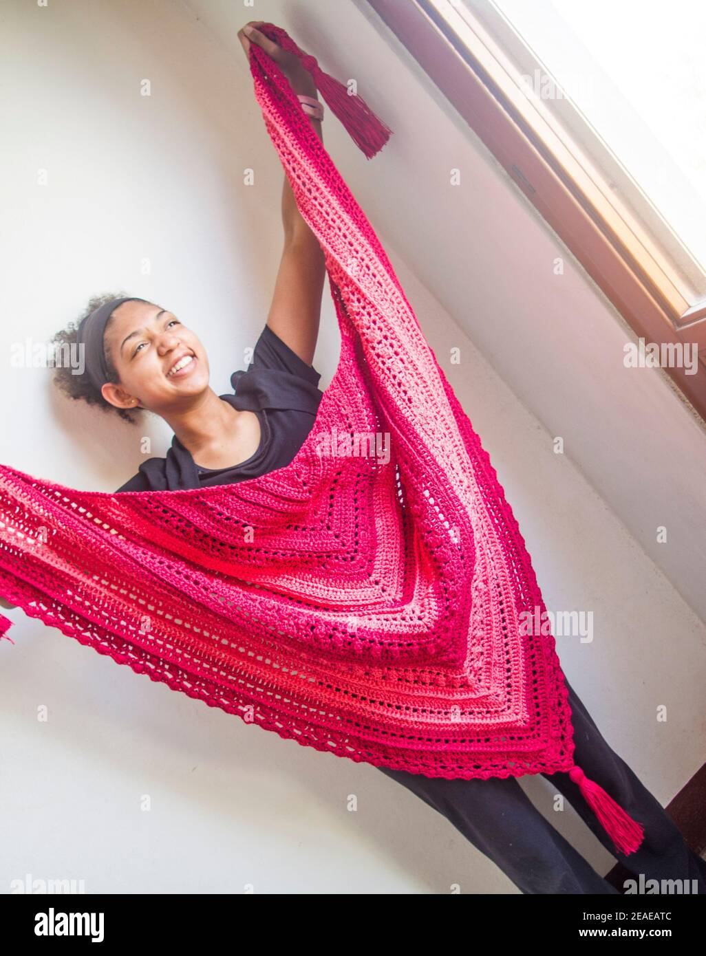 Elegant red and pink poncho or shawl tied by a young smiling and happy ...
