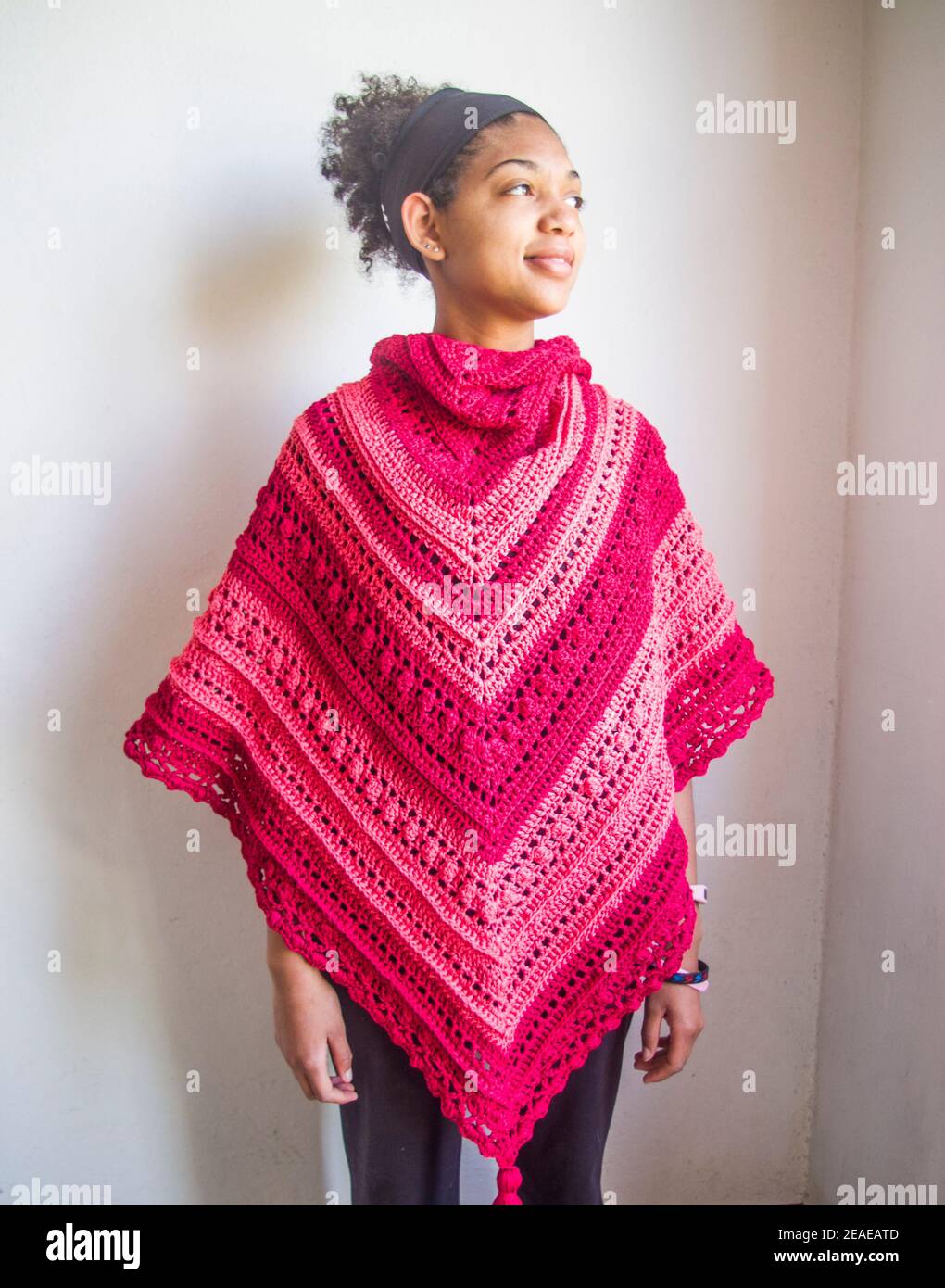 Elegant red and pink poncho or shawl tied by a young smiling and happy ...