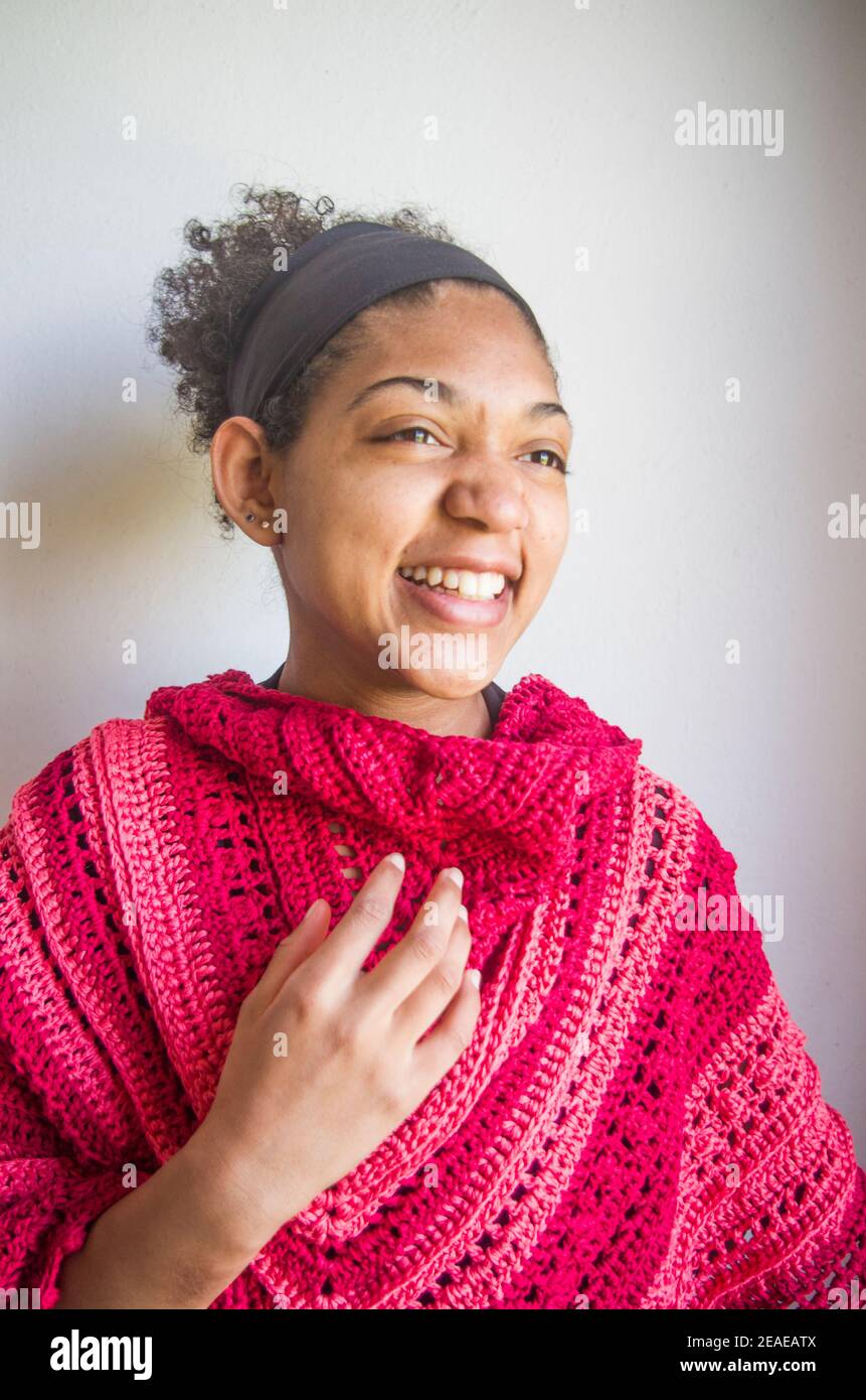 Elegant red and pink poncho or shawl tied by a young smiling and happy ...