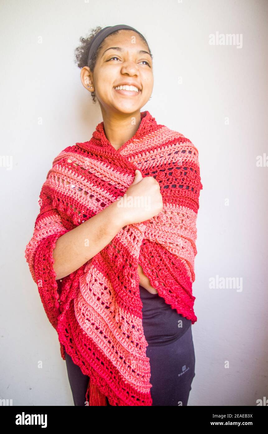 Elegant red and pink poncho or shawl tied by a young smiling and happy ...