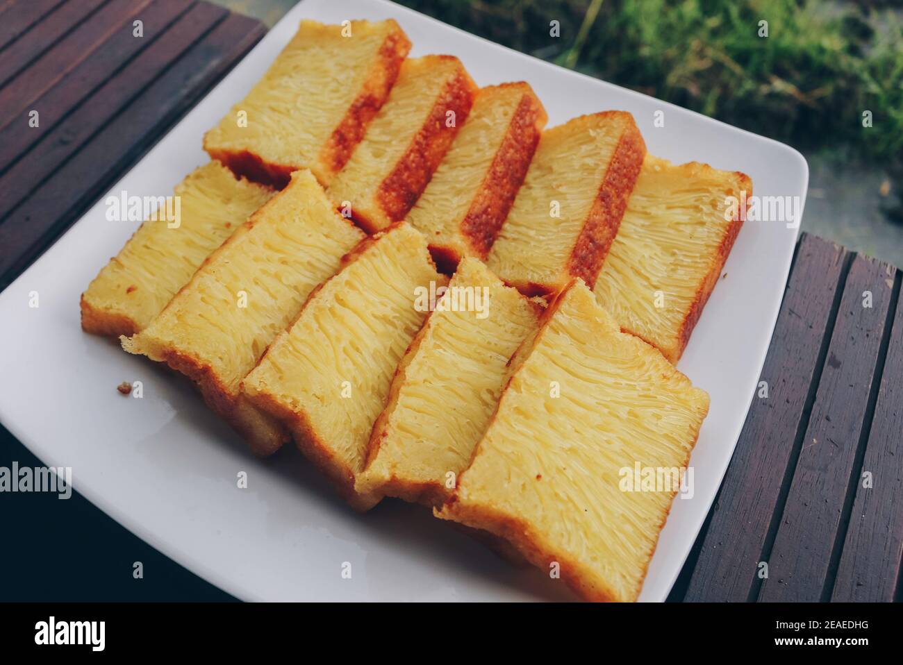 Bika Ambon, Indonesian cake with square slices in white plate. Yellow ...
