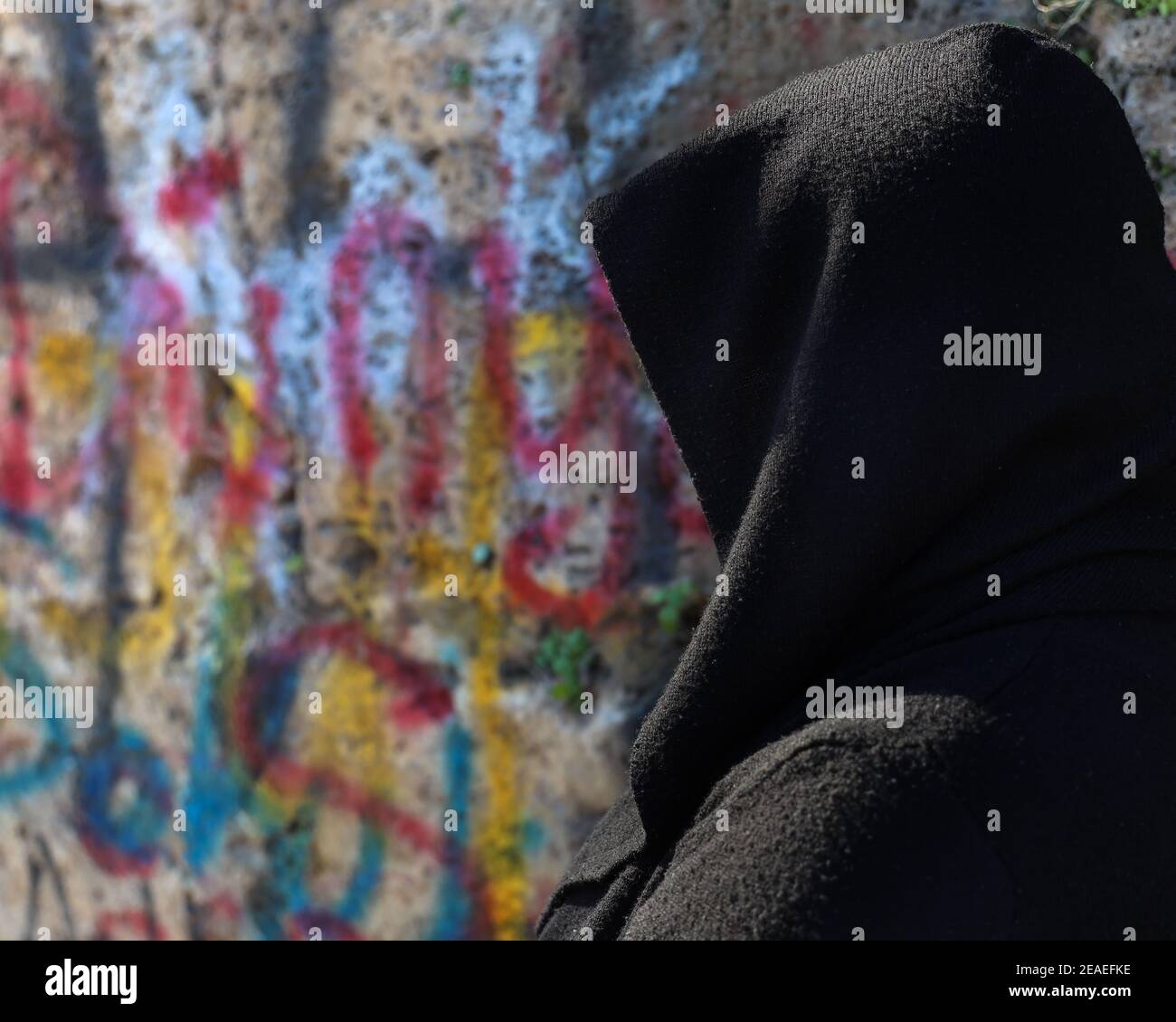 Selected Focus of a frightened woman in black dress with unrecognizable ...