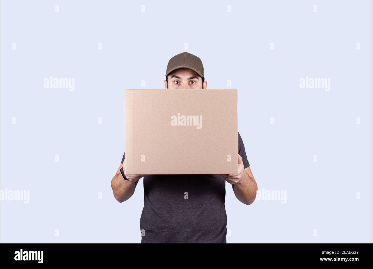 Surprised delivery man holding a box package. Shocked and astonished ...
