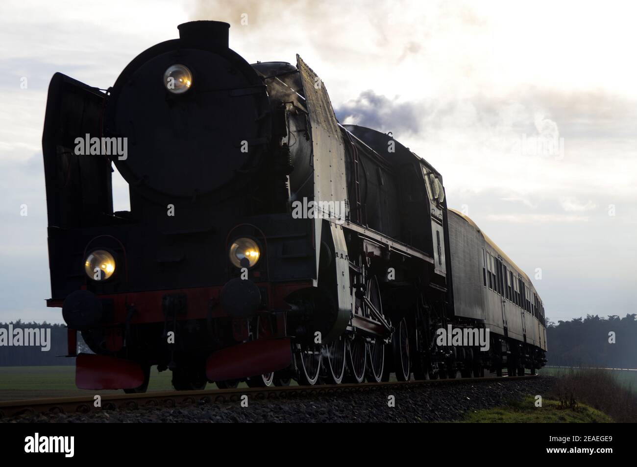Retro smoky steam locomotive. Old passenger train on the former railway ...